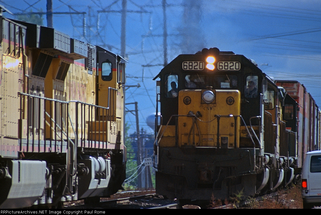 C&NW 6820, EMD SD40-2, works a northbound passing an empty hopper train at Grand Avenue